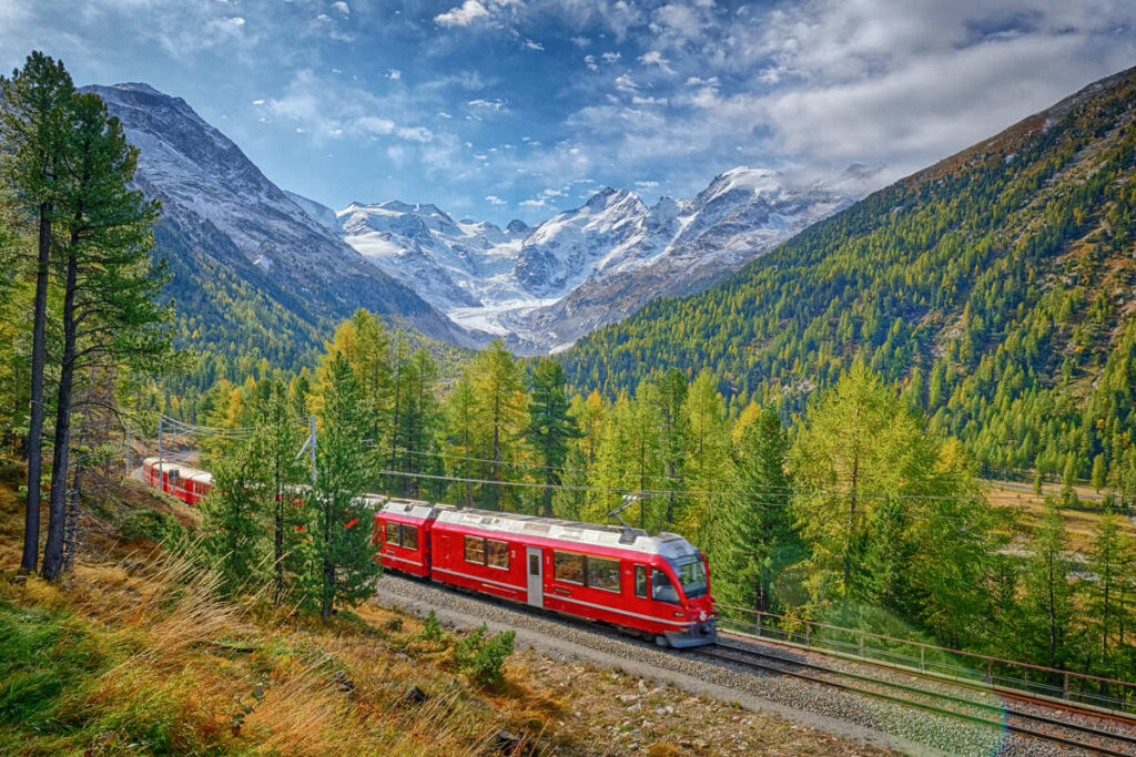 Red Train Traveling Through The Swiss Alps, Switzerland, Europe ...