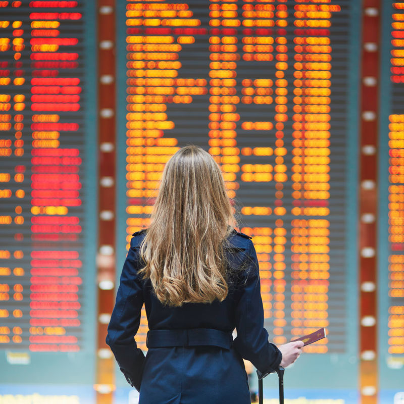 Woman Looking at Flight Screen - Travel Off Path