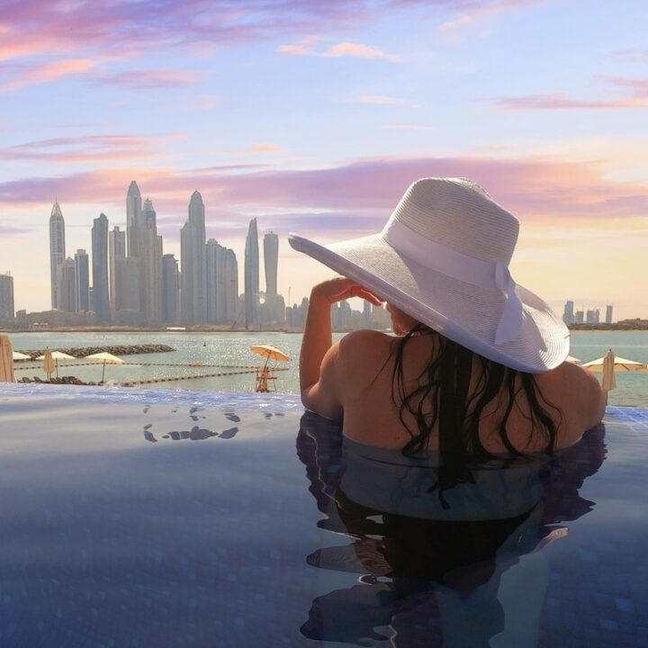 Young Woman Swimming At An Infinity Pool Overlooking Dubai, United Arab ...