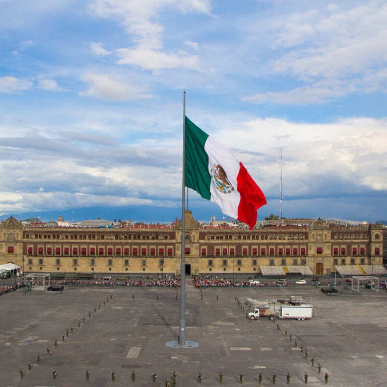 A Giant-Size Mexican Flag Flying Atop A Flagpole In A Central Square In ...