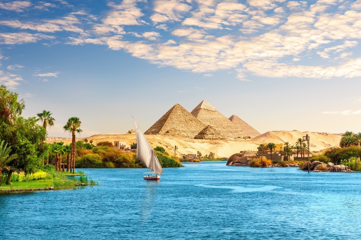 Boat Traveling Down The Nile With The Pyramids Of Giza For Background ...