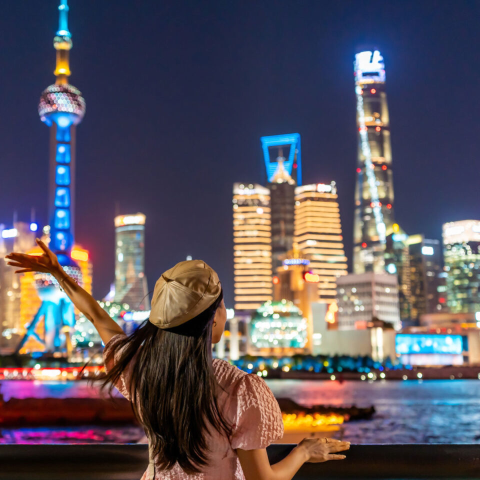 Woman-overlooking-Shanghai-skyline-at-night - Travel Off Path