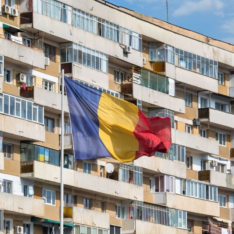 Romanian Flag Flying Against A Brutalist Apartment Block From The ...